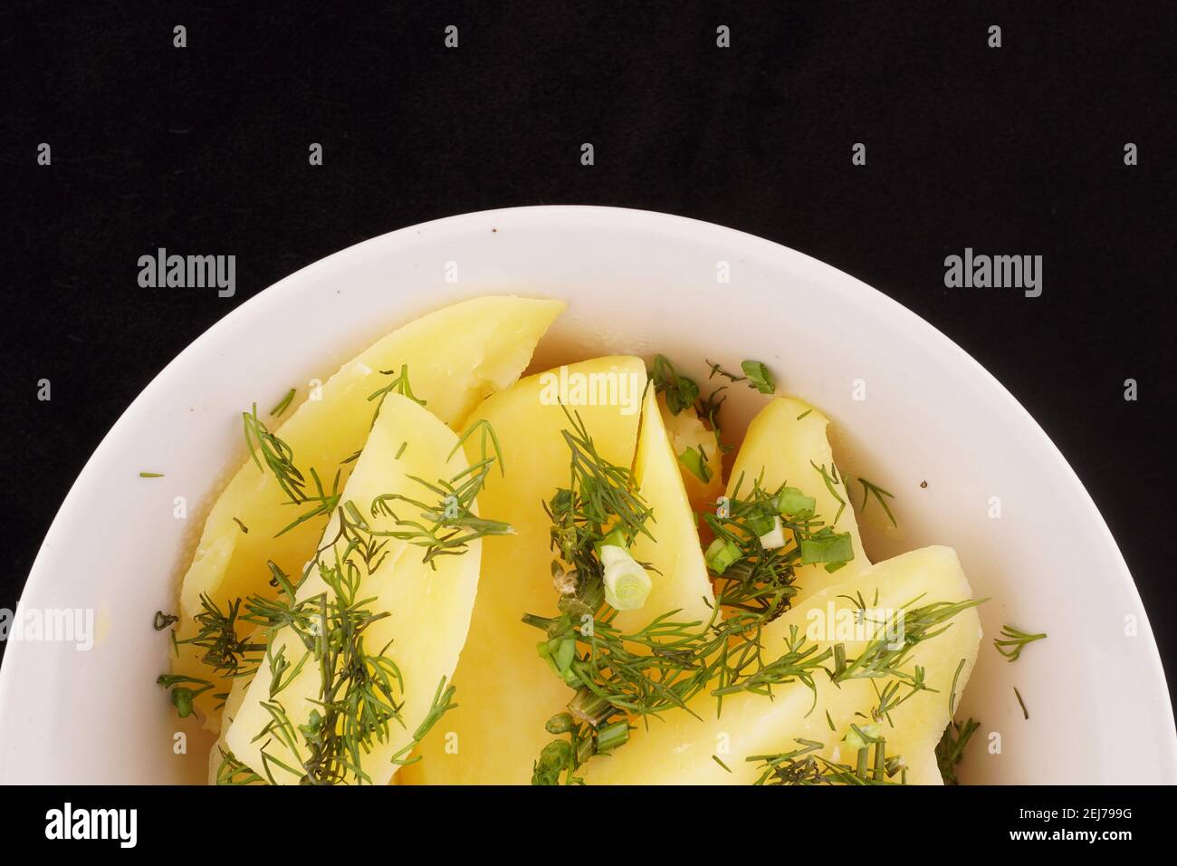 boiled potatoes on a black background Stock Photo - Alamy