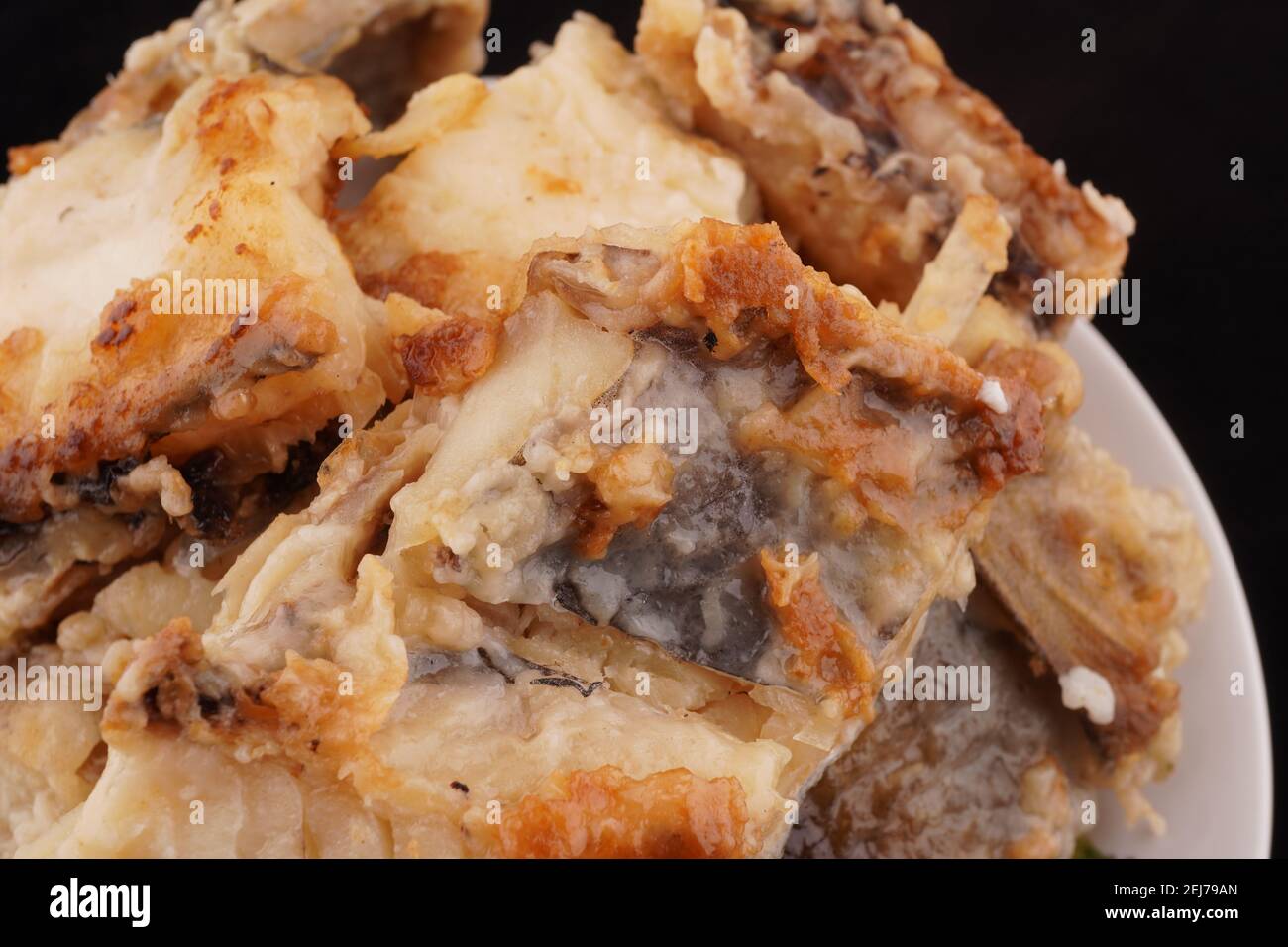fried fish on a black background Stock Photo - Alamy