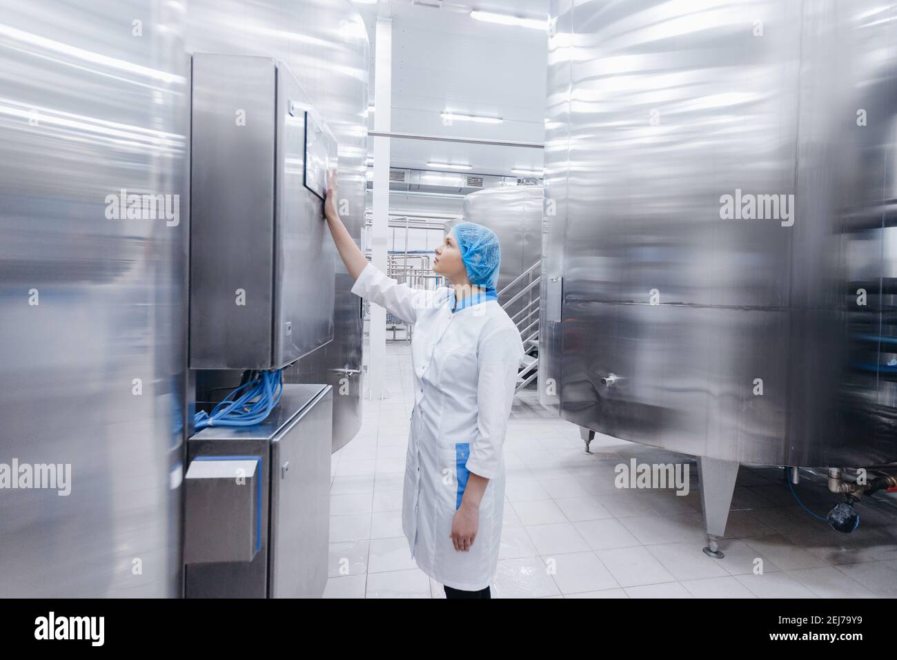 Worker female operator in uniform uses process control panel food ...