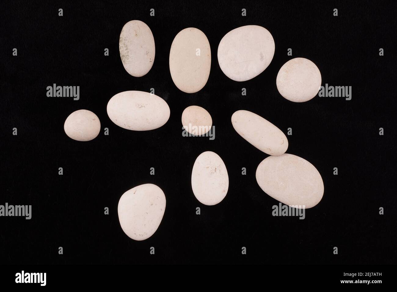 white round stones on a black background Stock Photo - Alamy