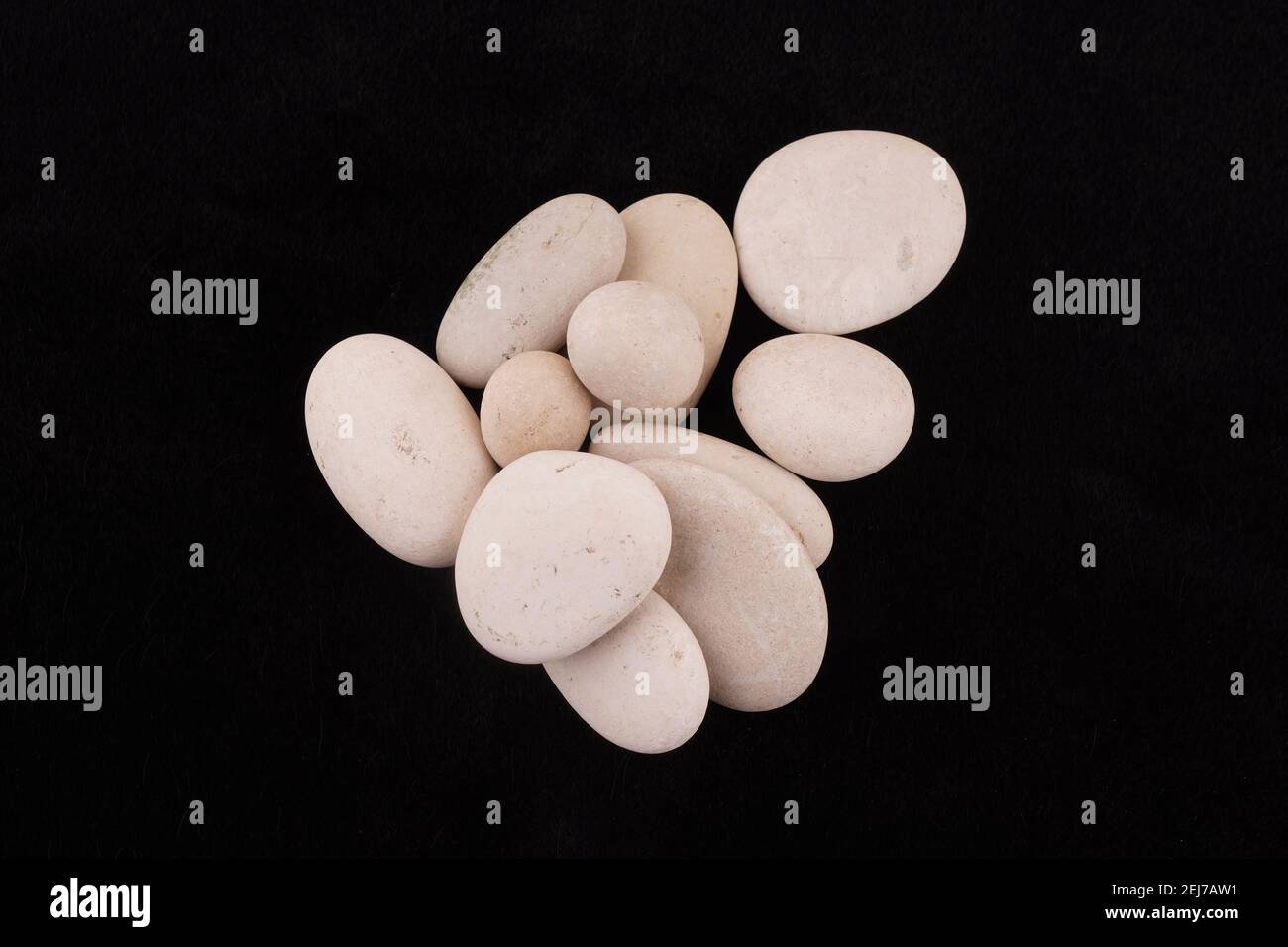 white round stones on a black background Stock Photo - Alamy