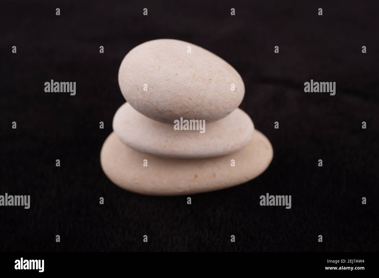 white round stones on a black background Stock Photo - Alamy