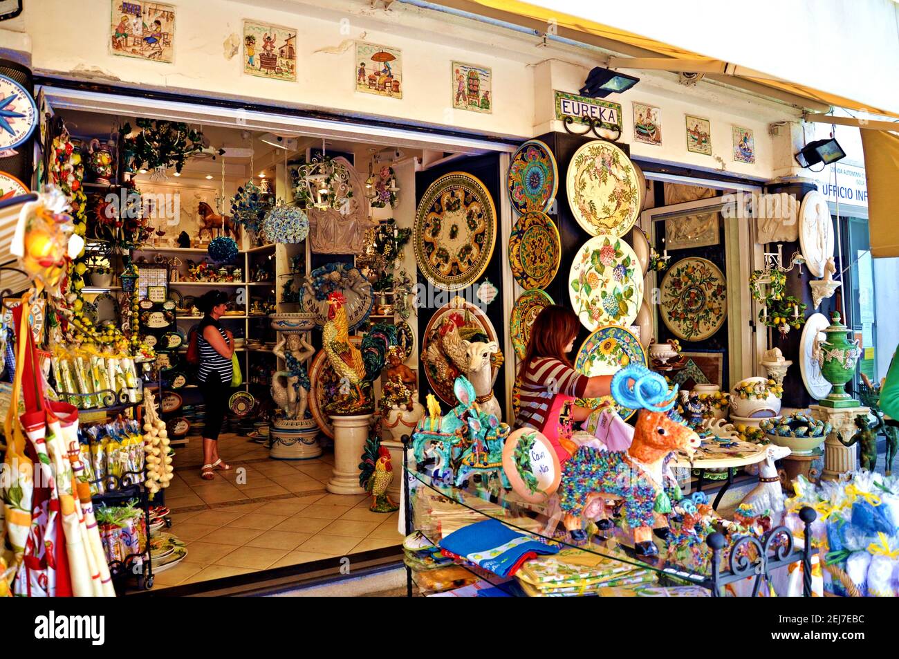 Shop on the street full of colorful objects, people shopping, front ...