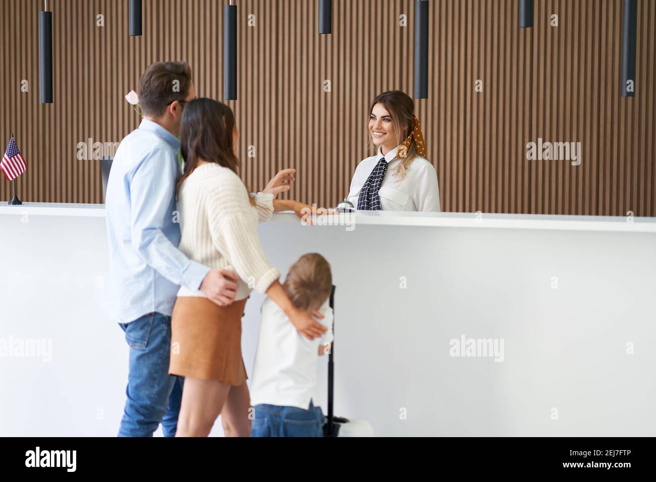 Picture of family checking in hotel Stock Photo - Alamy