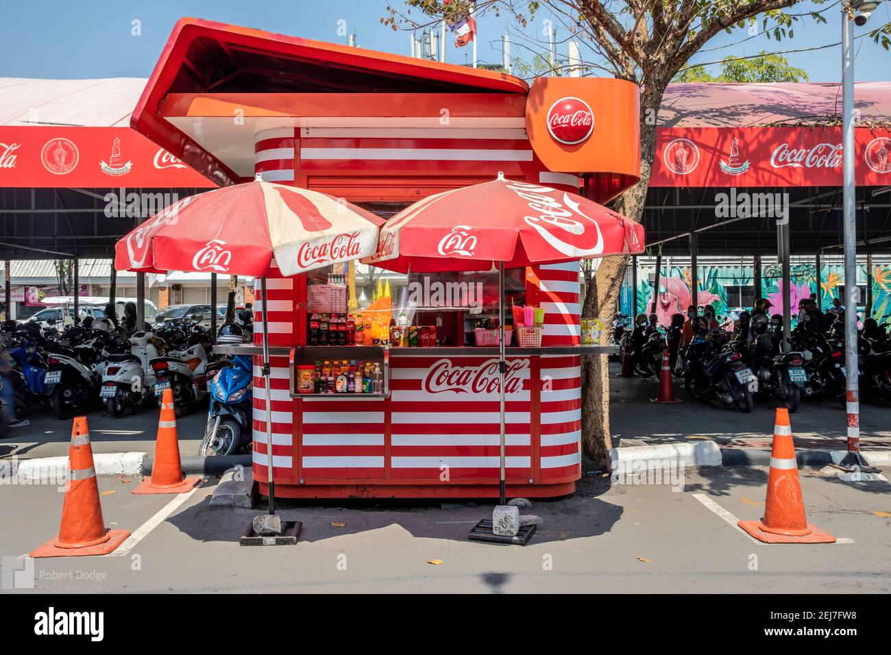 A bright red kiosk selling drinks sits adjacent to the parking lot for ...