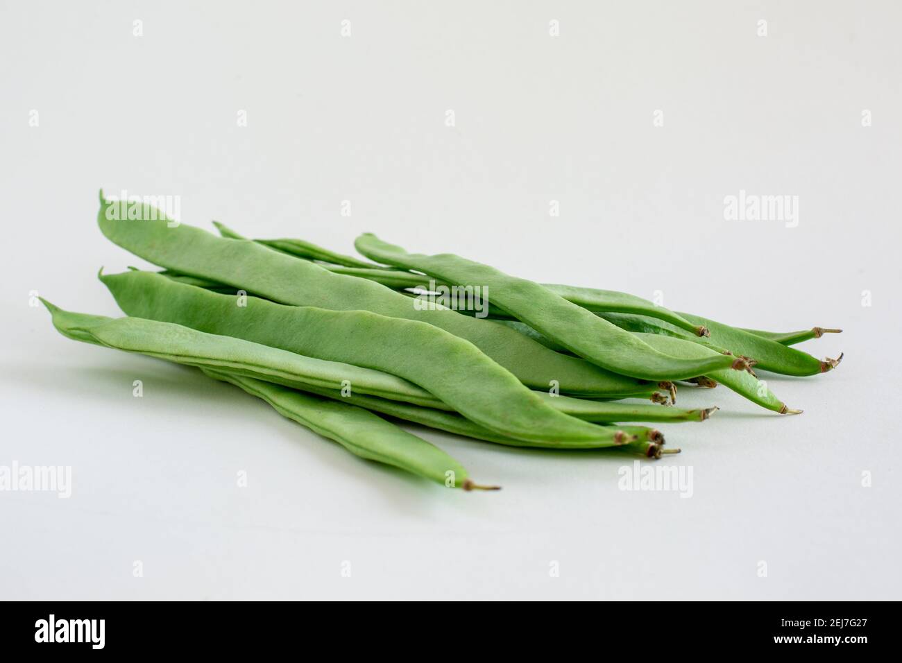 a group of fresh green flat runner beans on white background isolated ...