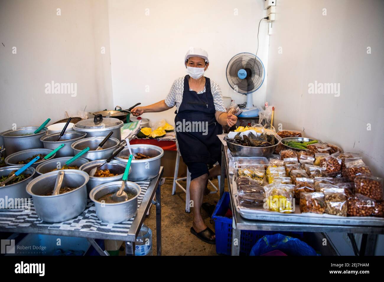 A woman street food merchant prepares fresh foods for lunch-time ...