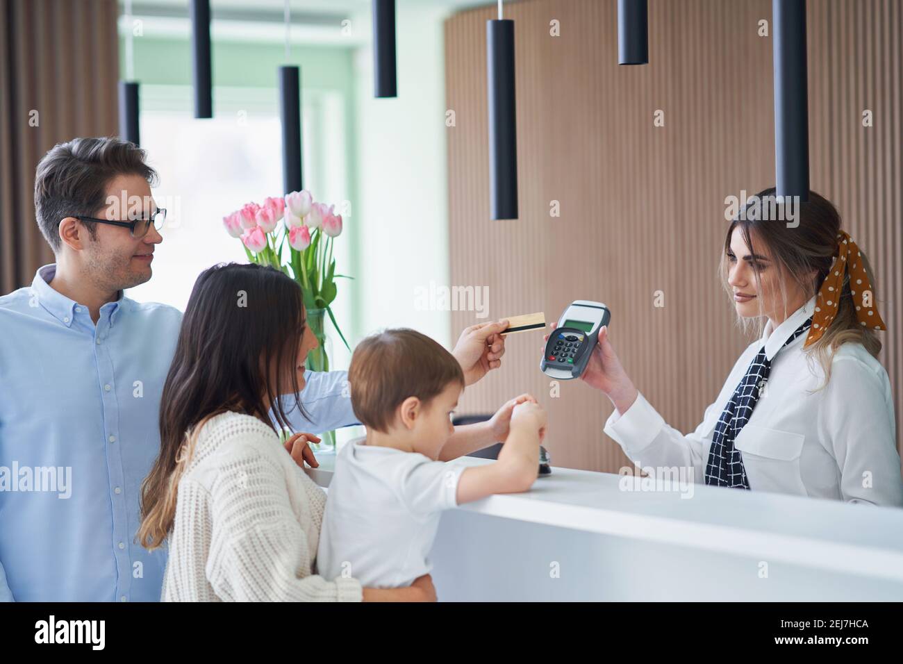 Picture of family checking in hotel Stock Photo - Alamy