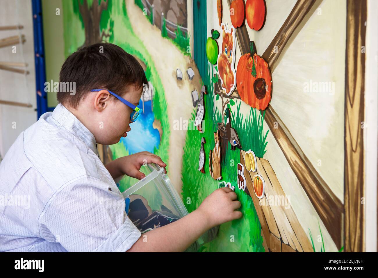 Editorial. A teenage boy with disabilities plays with pictures on a ...