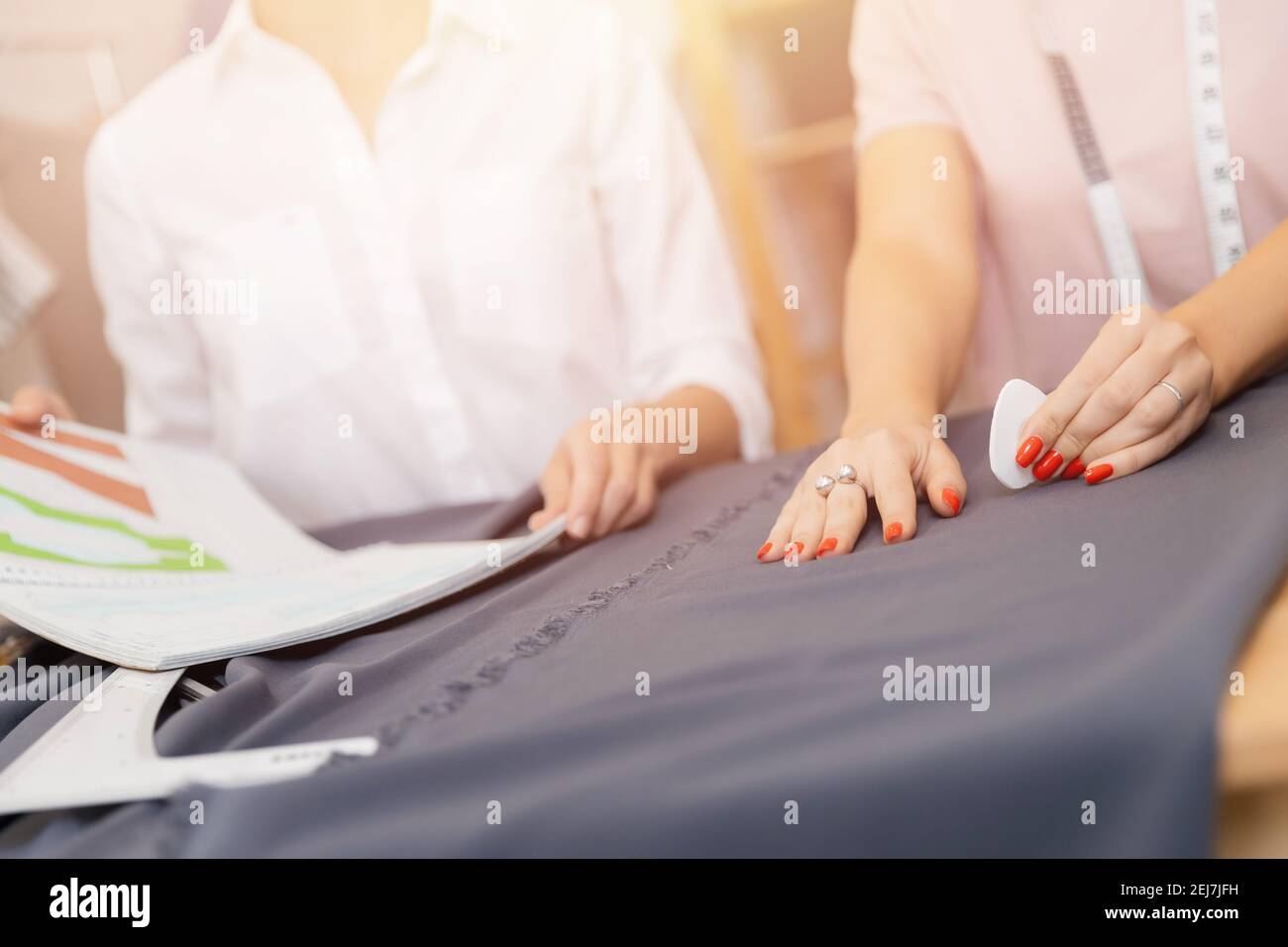Two woman dressmaker making pattern on grey material. Sew work, top ...