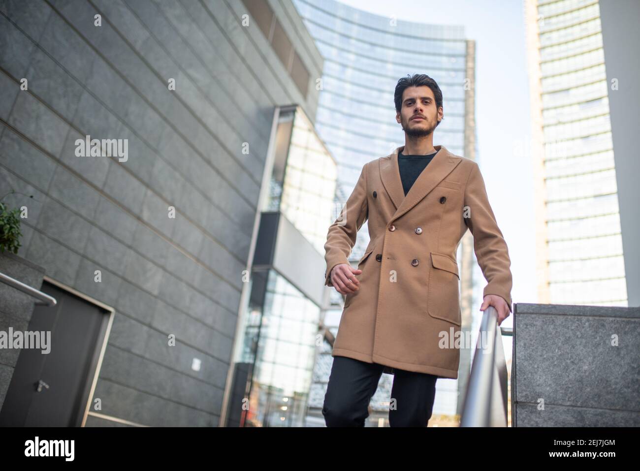 Handsome young man walking down the stairs in a modern city Stock Photo ...