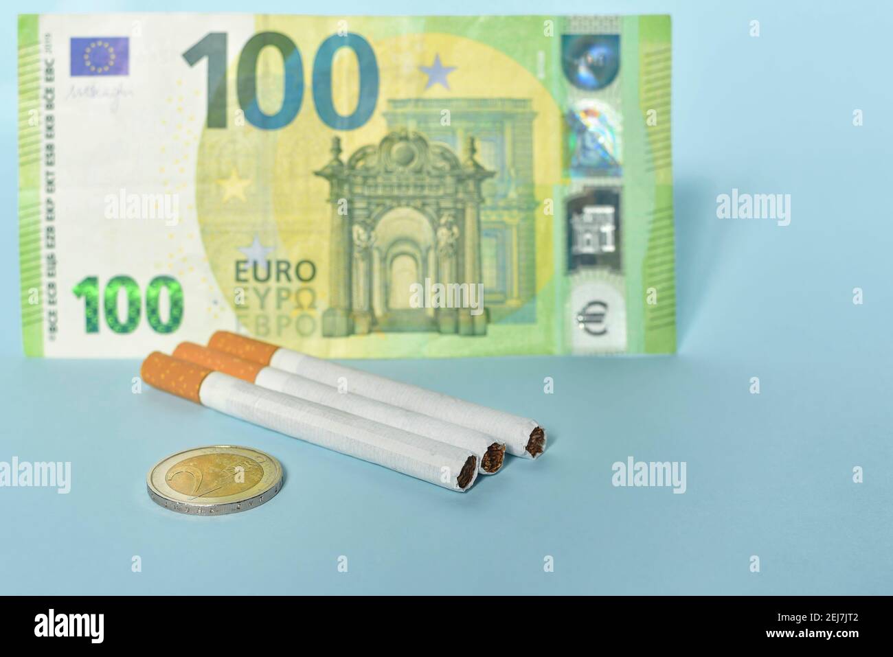 Cigarettes and money on blue background. Euro banknotes and coins, cost ...