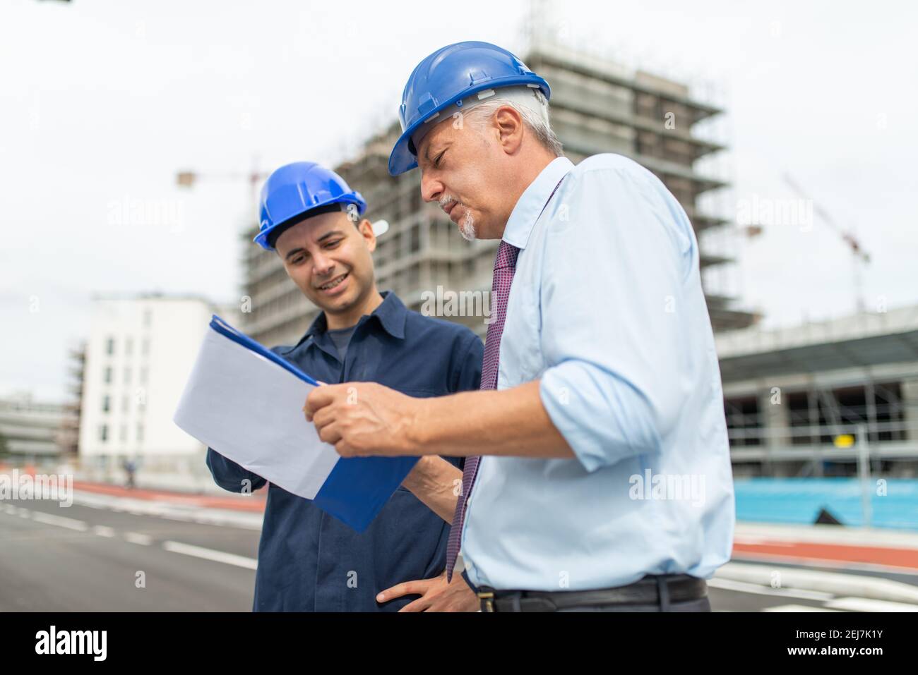 Two architect developers reviewing building plans in front of their ...