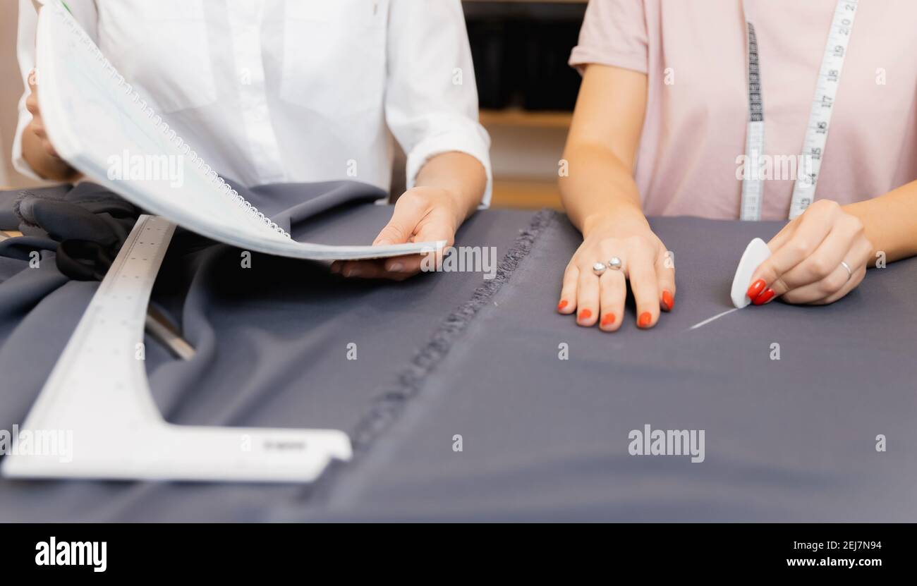 Sew working, two woman dressmaker making pattern on grey material Stock ...