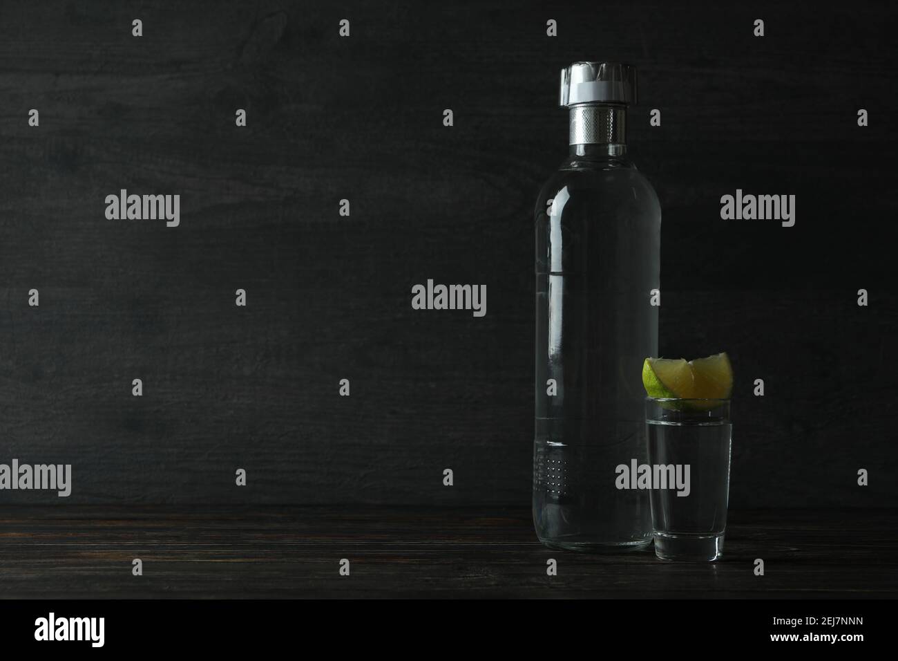 Blank bottle of vodka and shot with lime slice on wooden background ...