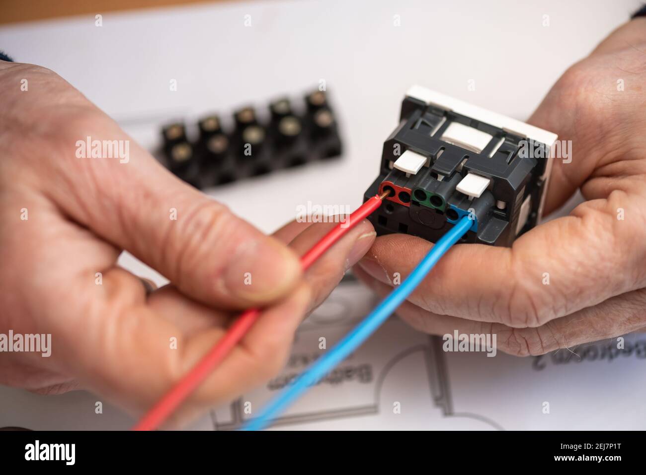 Electrician hands connecting a wire into a power socket Stock Photo - Alamy