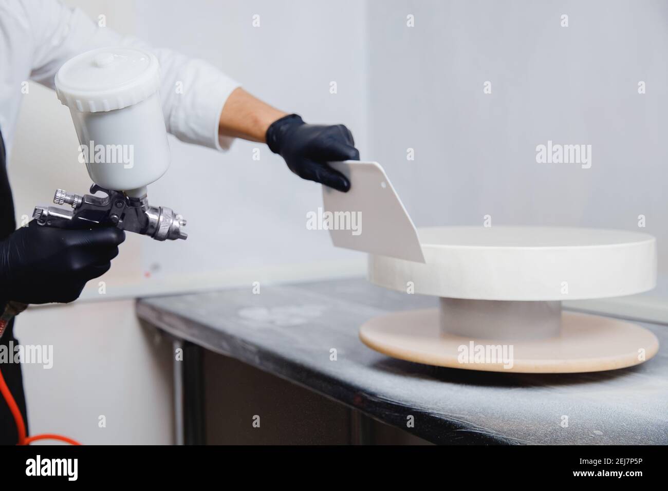 Applies hot chocolate painting to surface of cake with spray gun pastry ...