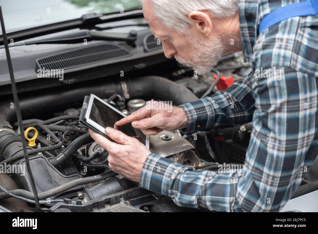 Car mechanic using digital tablet for checking car engine Stock Photo ...