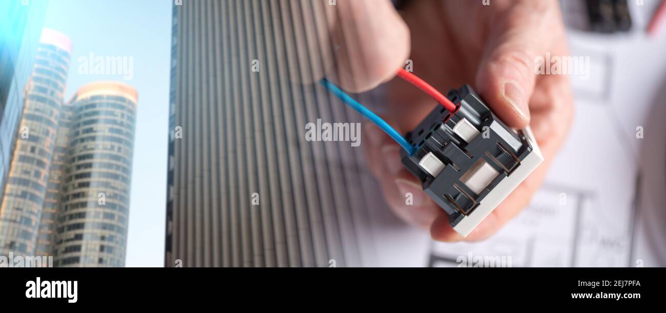 Electrician hands connecting a wire into a power socket; multiple ...