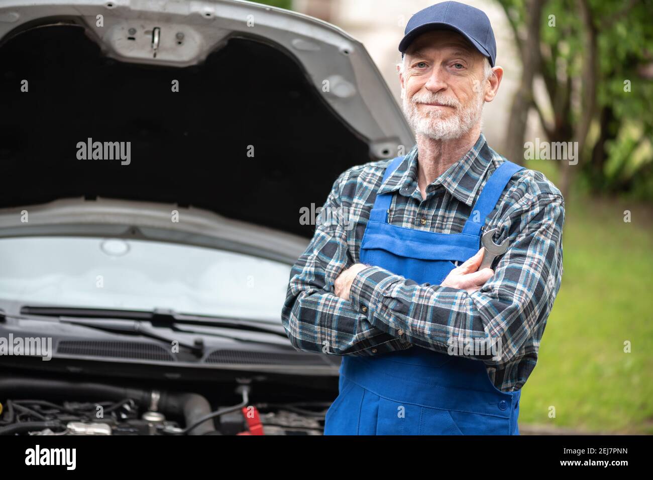 Portrait of senior car mechanic with arm crossed Stock Photo - Alamy