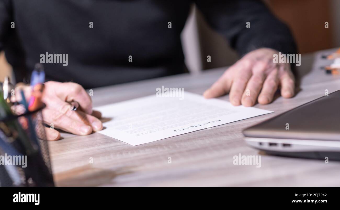 Senior businessman reviewing terms of contract at office Stock Photo ...