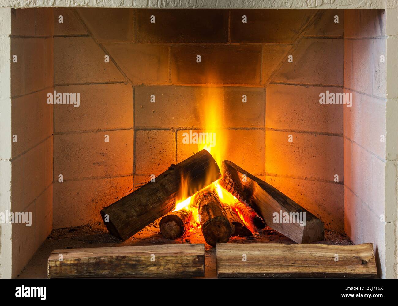 Fireplace with burning firewood made with bricks Stock Photo - Alamy