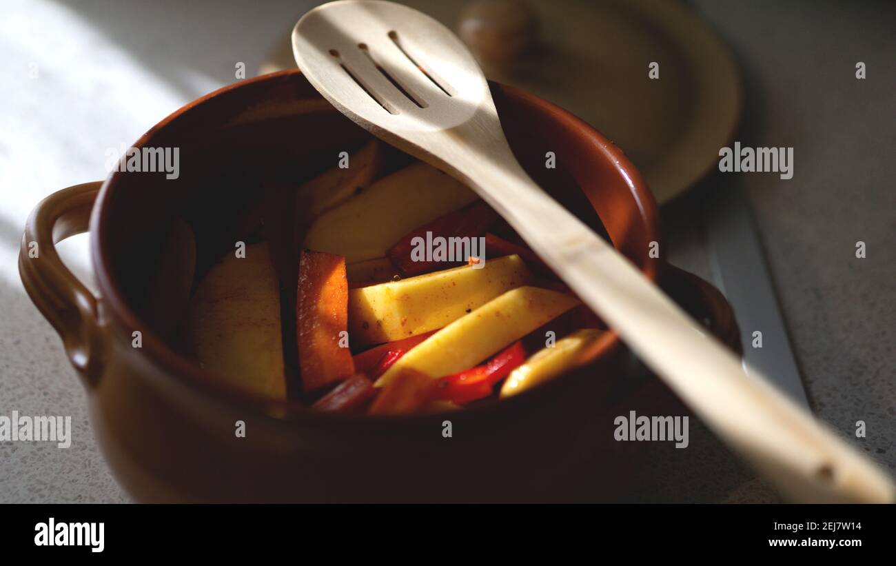 Raw vegetable ready to cook in ceramic slow cooking pot. Clay pot home ...