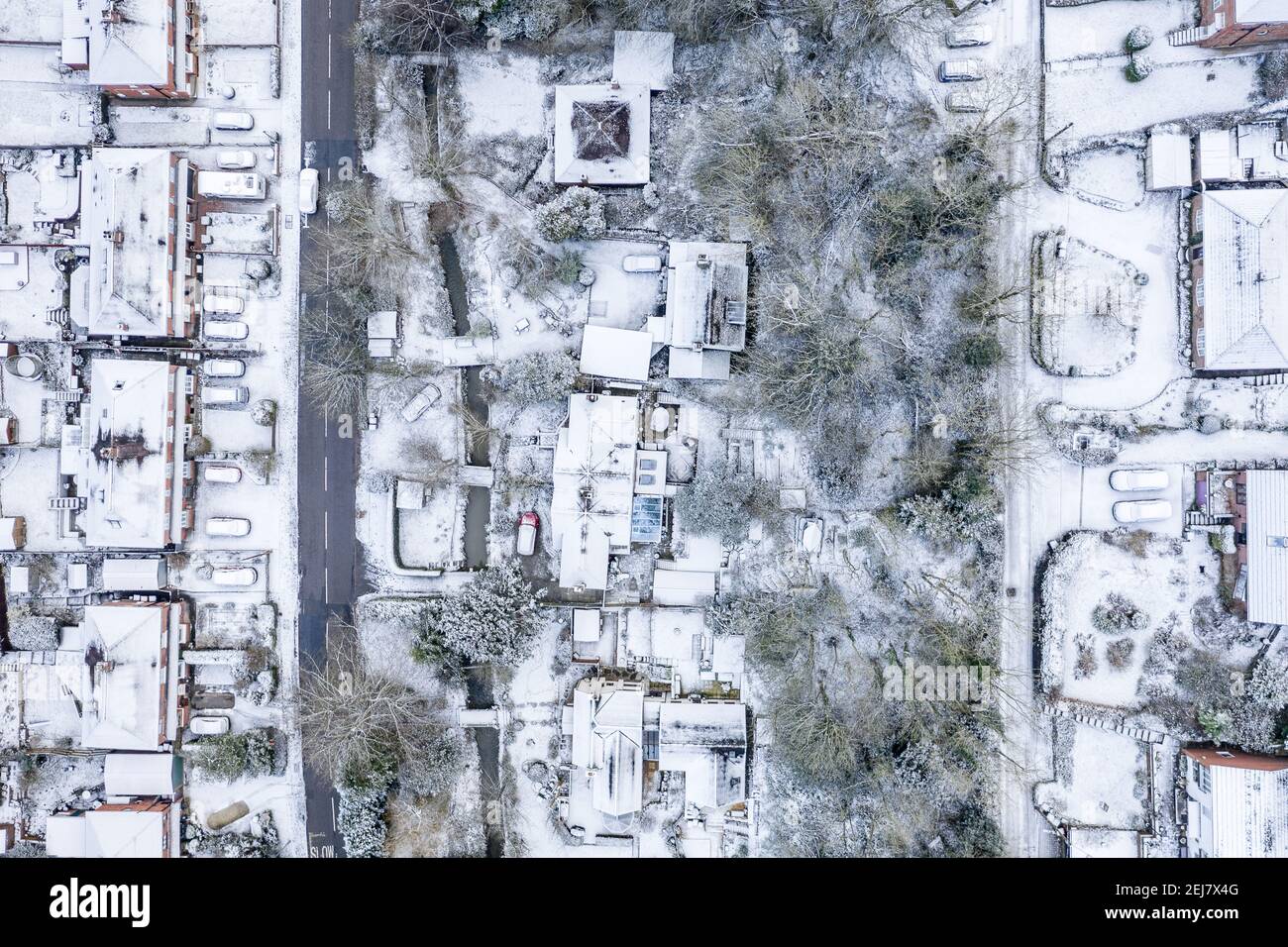 Top down aerial view over snow covered residential area. The thin layer ...