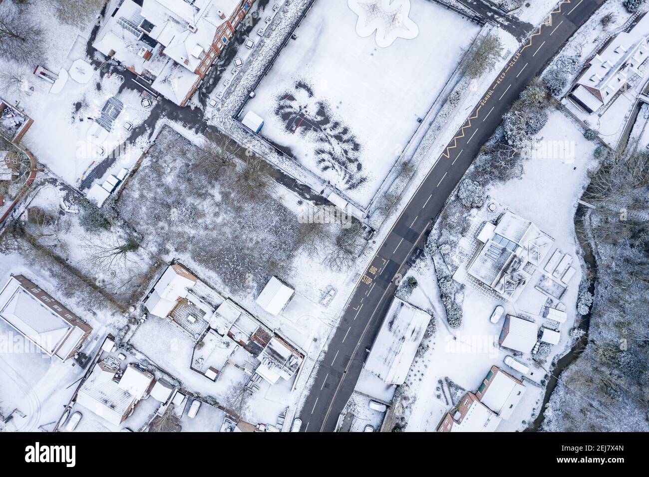 Top down aerial view over snow covered residential area. The thin layer ...