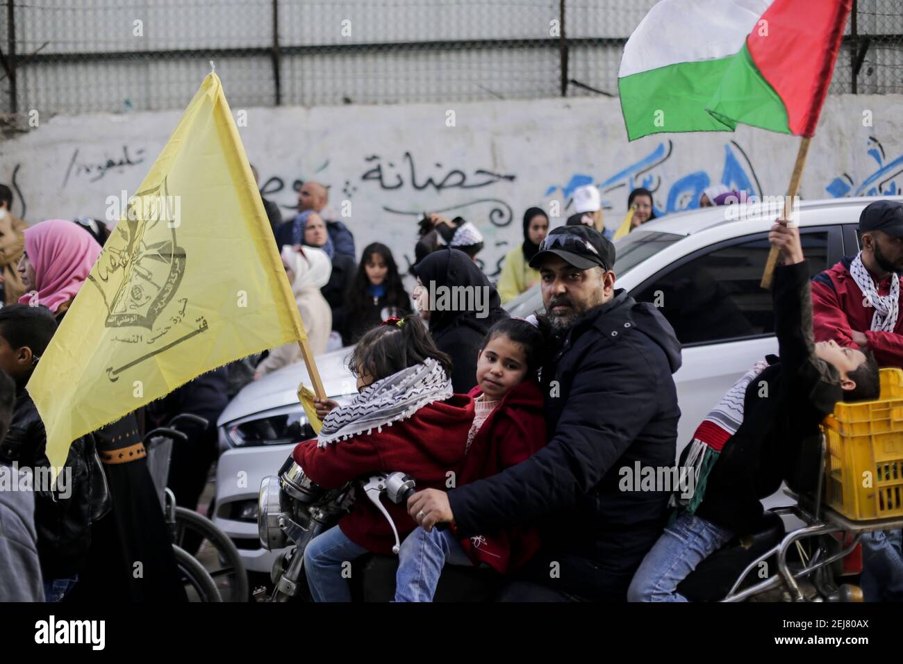 Palestinians waving flags during a rally marking the 55th anniversary ...