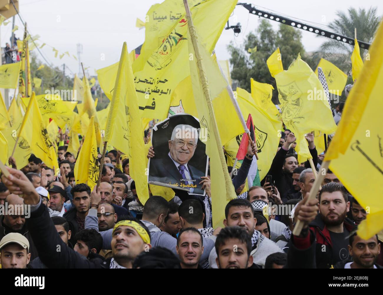Palestinians waving yellow Fatah flags during a rally marking the 55th ...