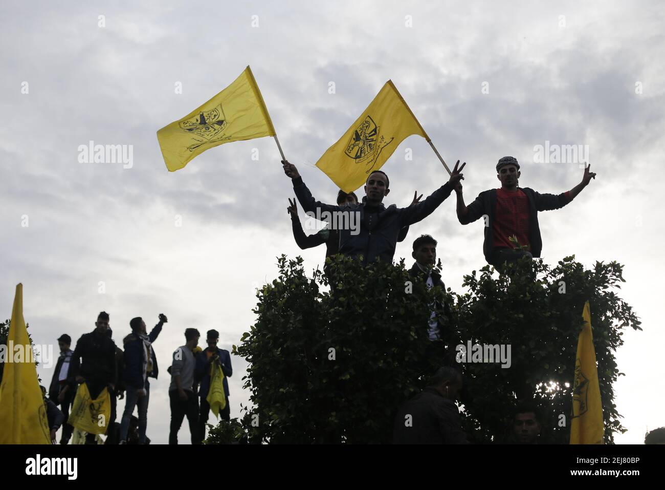 Palestinians waving yellow Fatah flags during a rally marking the 55th ...
