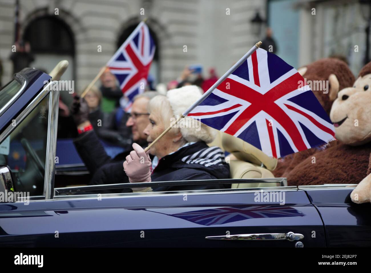 Members of Rolls Royce club holding UK Flags drive through the parade ...