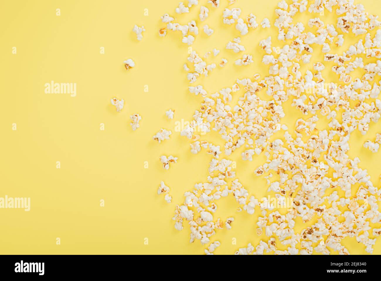 top view of crunchy popcorn scattered on yellow, cinema concept Stock ...