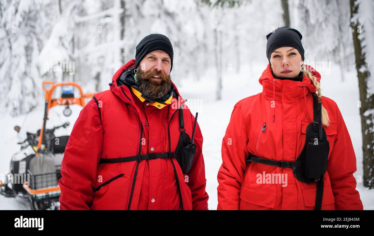 Woman and man paramedic from mountain rescue service outdoors in winter ...