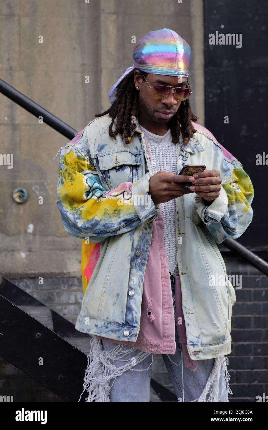 Trendy Fashionista using his mobile phone attends the London Fashion ...