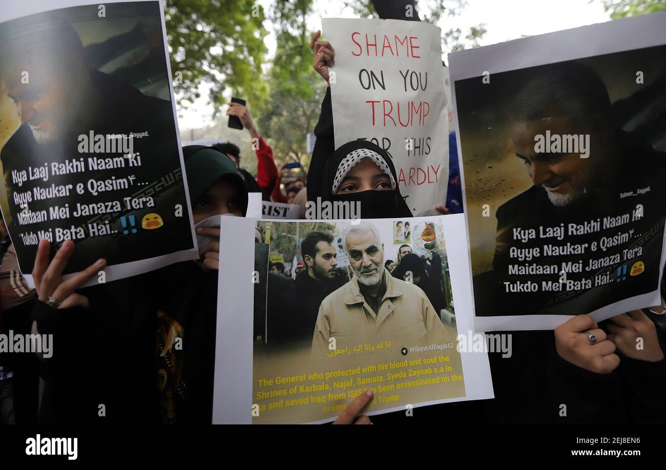 Shia Muslim community people hold portraits and a placard during the ...