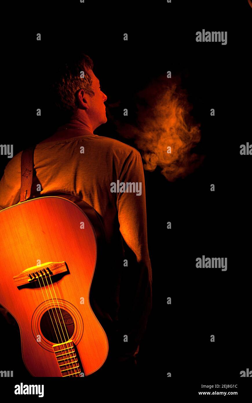 Musician with Guitar Smoking Stock Photo - Alamy
