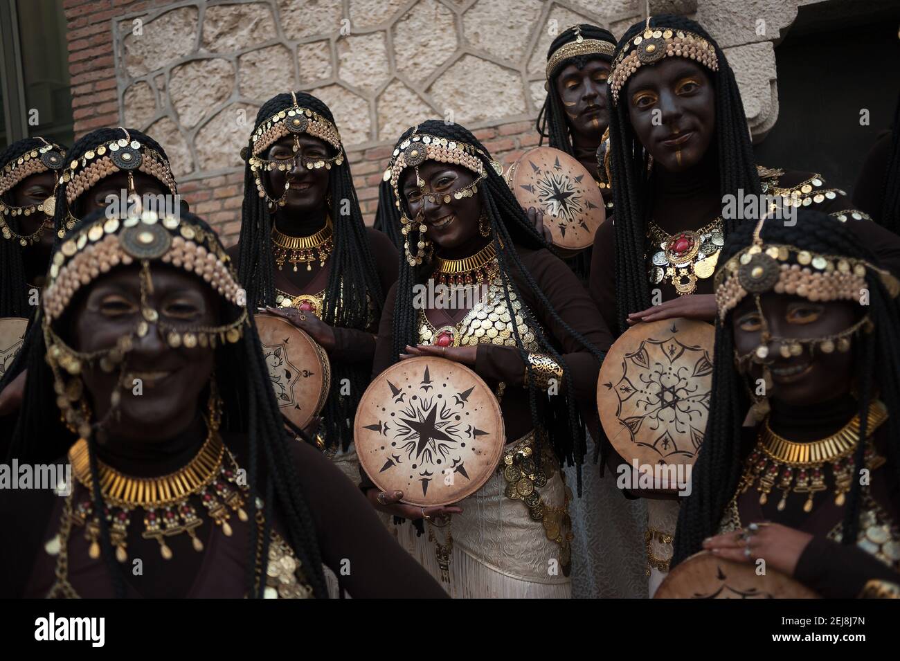 Women dressed with fantasy costumes pose for a photo on the street as ...