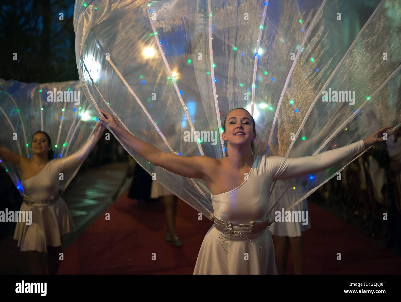 Women dressed in fantasy costumes perform on the street during the ...