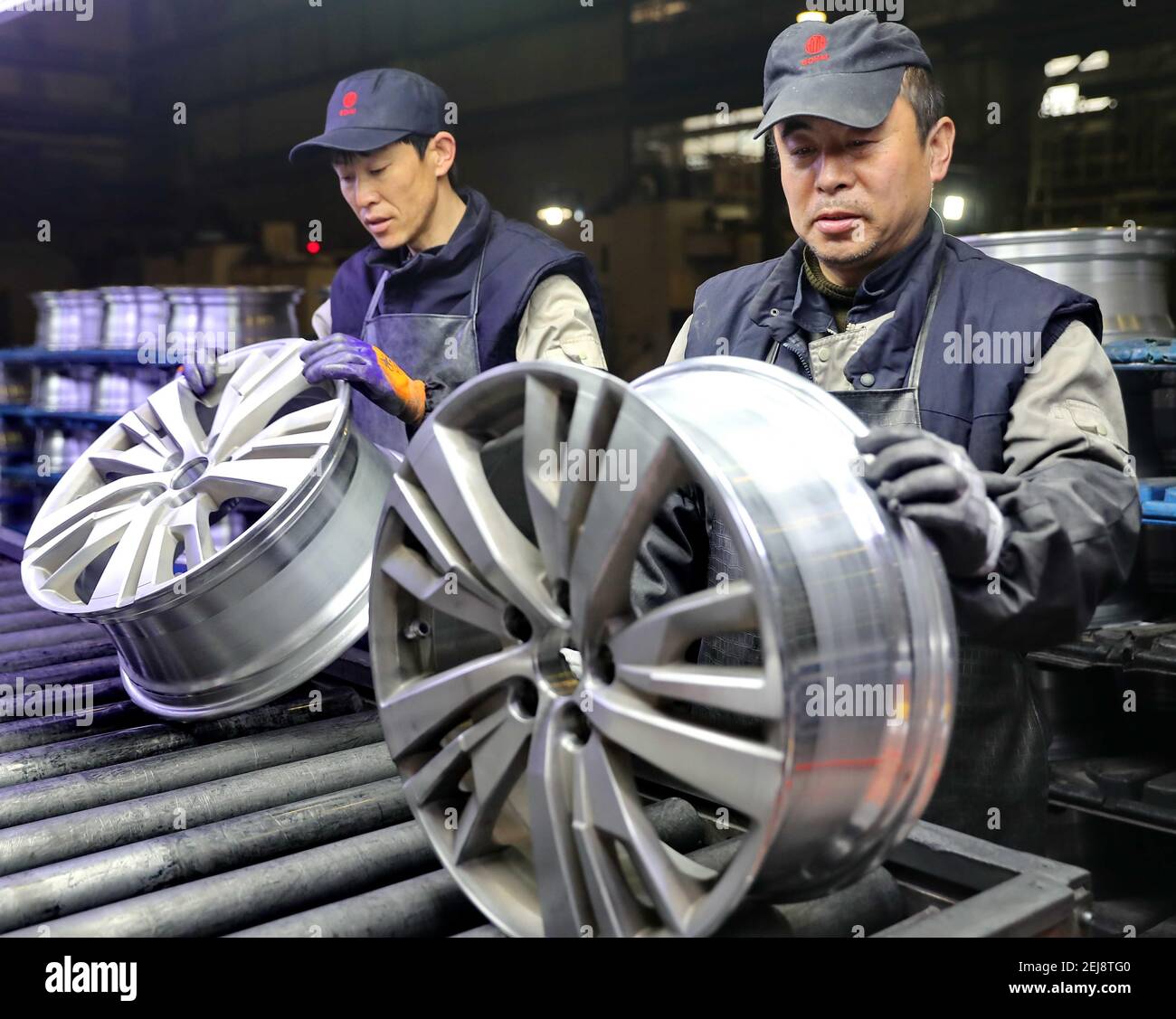 Chinese workers check aluminum car rims on the production line at a rim ...