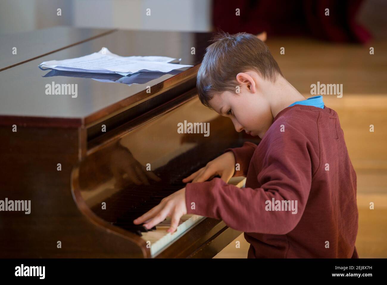 Kid playing the piano at lesson and event. Kids back to school concept ...