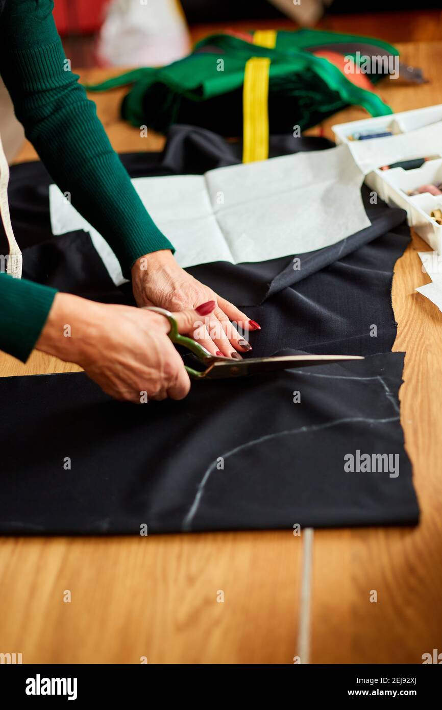 Step by step, Woman dressmaker hands cutting material with scissors on ...