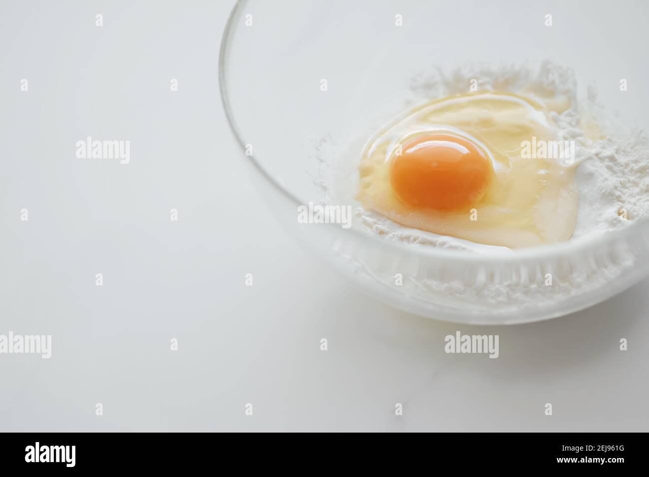 Raw egg and flour, preparing batter for baking process Stock Photo - Alamy