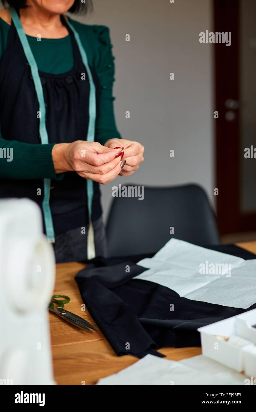 Step by step, woman dressmaker pulling thread into the needle, Mature ...