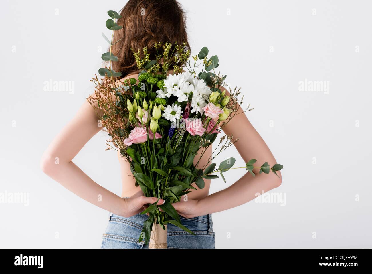 Back view of model in jeans holding flowers isolated on grey Stock ...