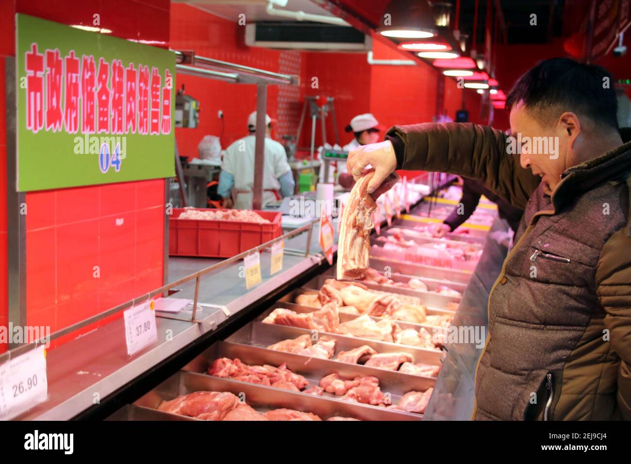Chinese customers shop for pork and other meat products at a ...
