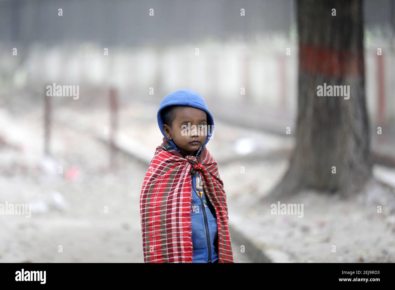 A kid poses for a photo during the cold weather in Dhaka. The colds ...