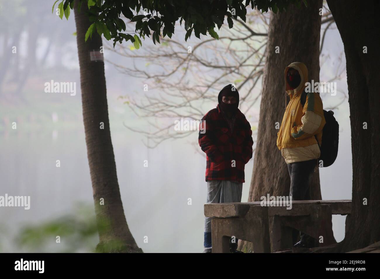 People take shelter at a park during the cold weather in Dhaka. The ...