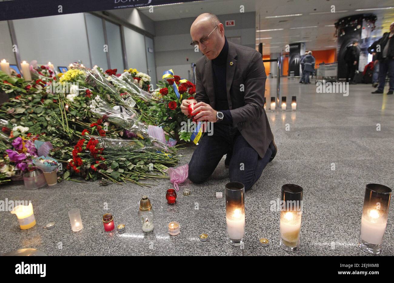 A man lights up candles and place them at the memorial corner of flight ...